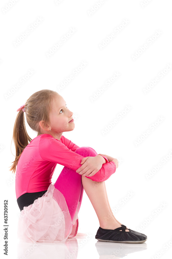 Little girl sitting on the floor, Side view. Stock Photo | Adobe Stock
