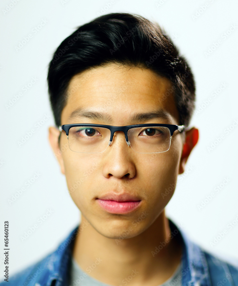 Closeup portrait of a young serious asian man on gray background Stock ...