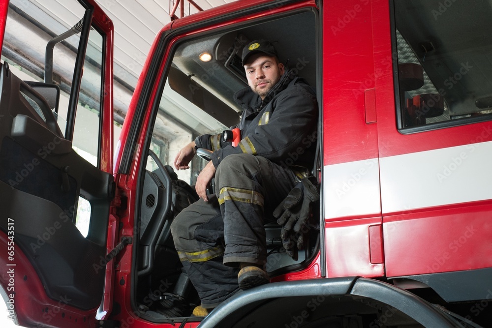 Fireman behind steering wheel of a firefighting truck foto de Stock ...