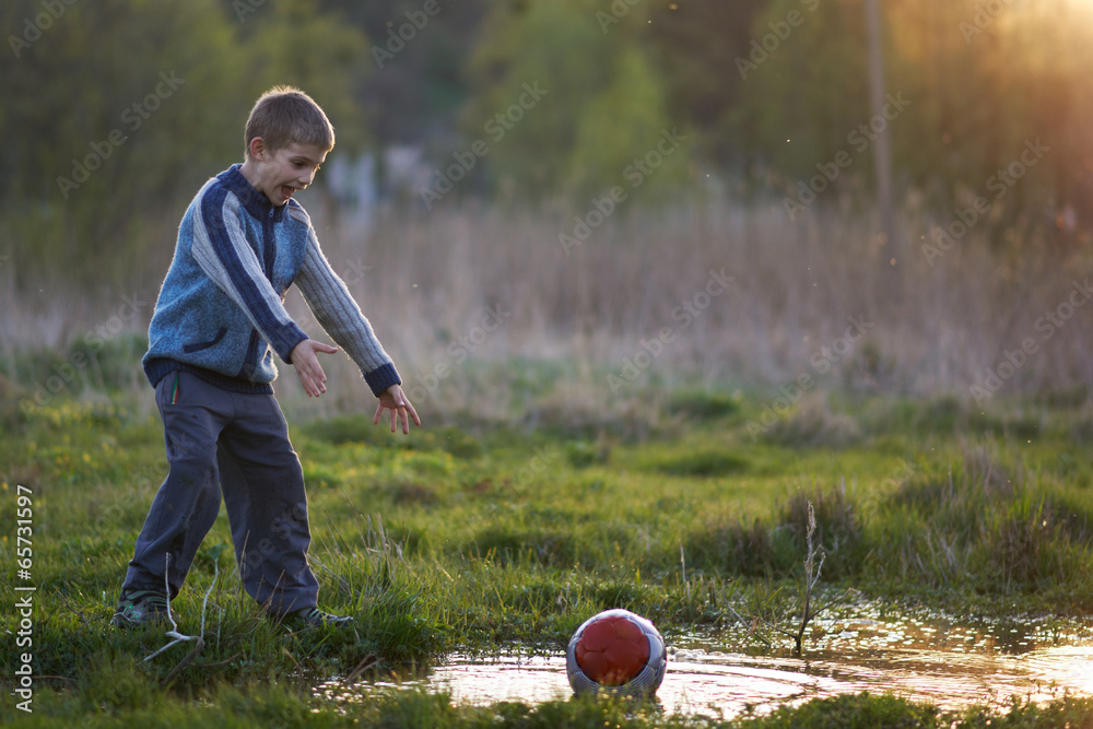 boy dropped the ball in a puddle and shouts Stock Photo | Adobe Stock
