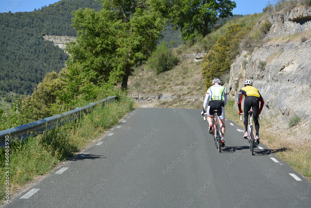 dos ciclistas subiendo un puerto de montaña foto de Stock | Adobe Stock