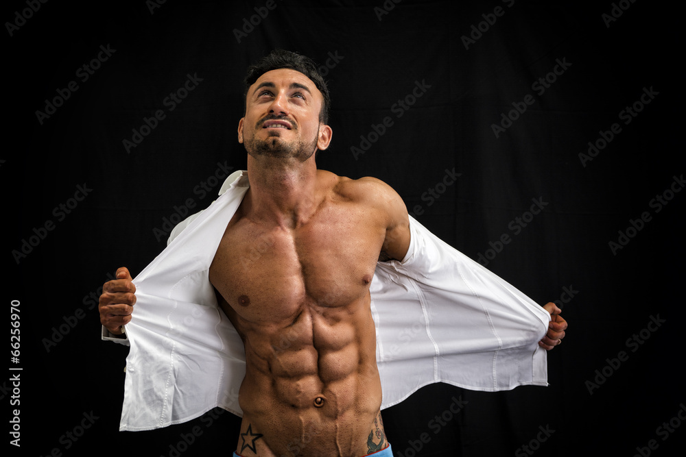 Male bodybuilder taking off his shirt revealing muscular torso Stock ...