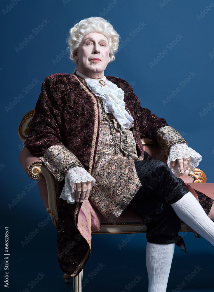 Retro baroque man with white wig sitting on antique couch. Studi Stock ...