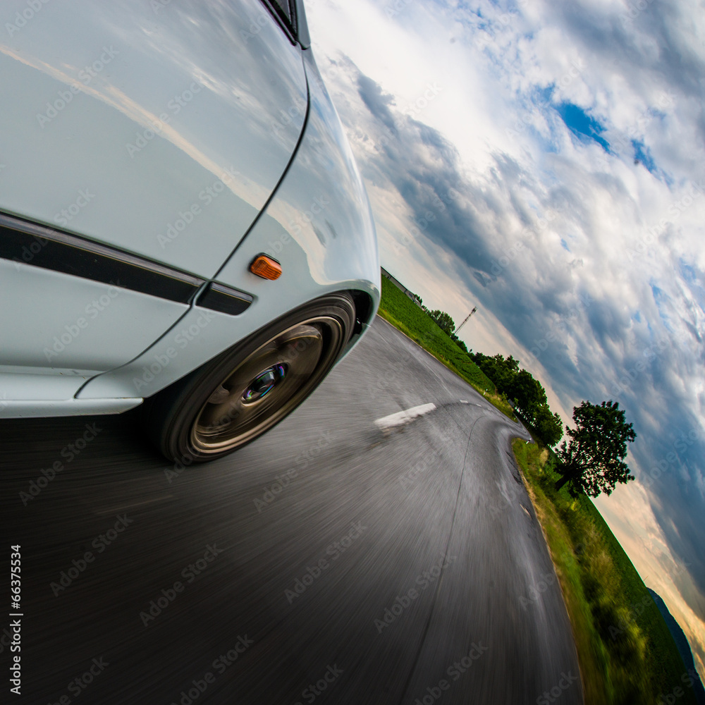 Driving in the curve - Front side view of white car driving fast Stock ...