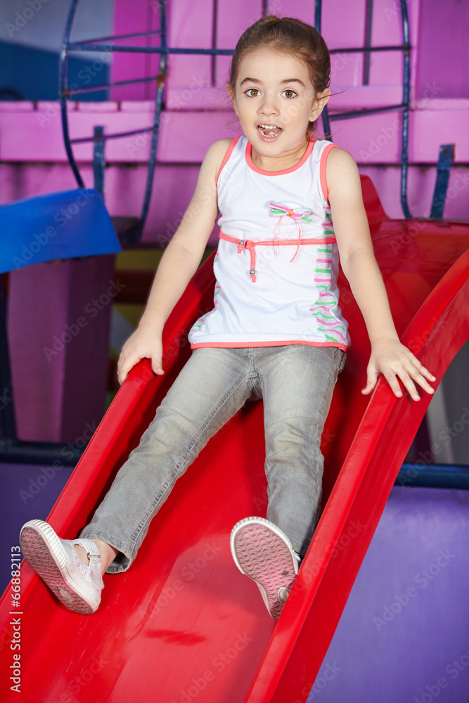 Scared girl on slide in kindergarten Stock Photo | Adobe Stock