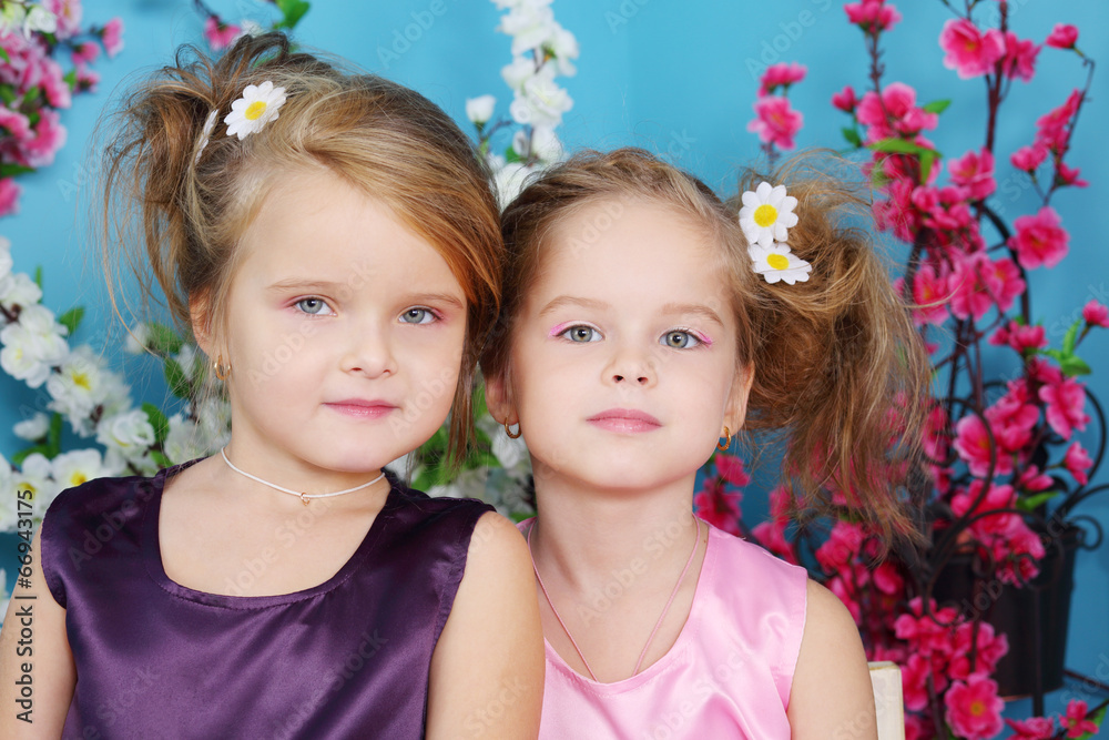 Two cute little girls in dresses look at camera in room Stock Photo ...