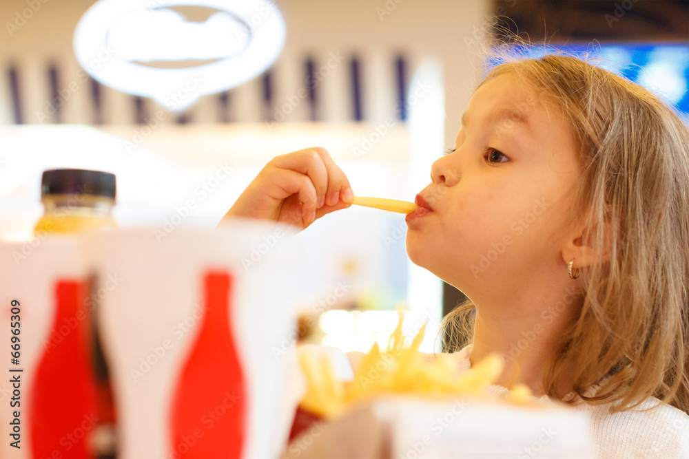 Little girl eating fast food french fries Stock Photo | Adobe Stock