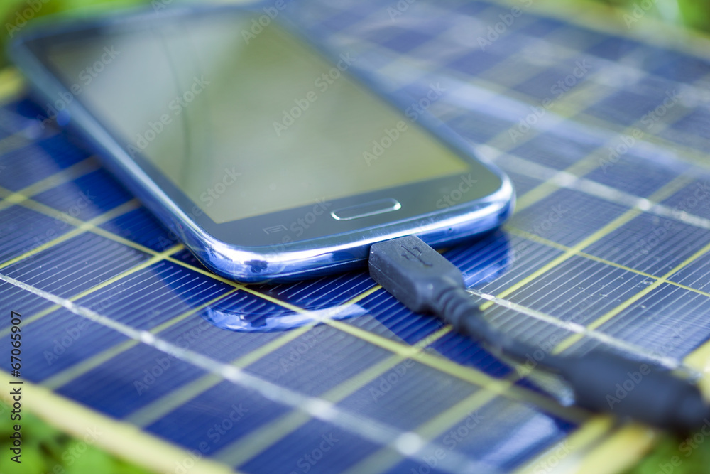 Charging smart-phone with solar charger Stock Photo | Adobe Stock