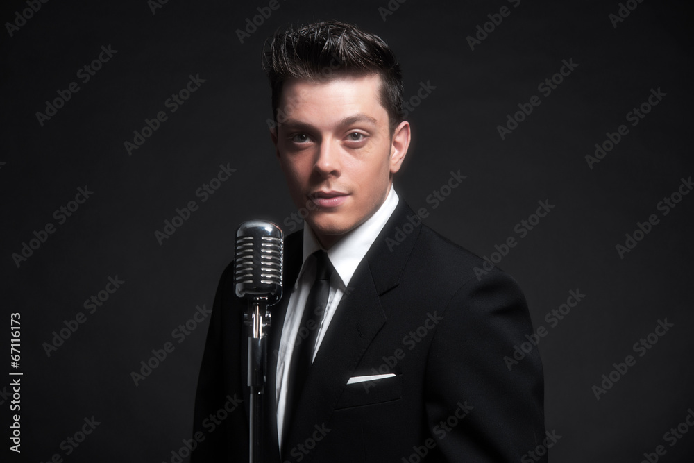 Retro fifties male singer with vintage microphone. Wearing black Stock ...