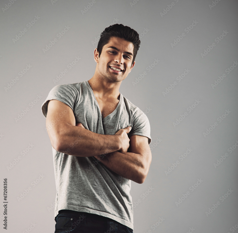 Smart young muscular man posing against grey background Stock Photo ...