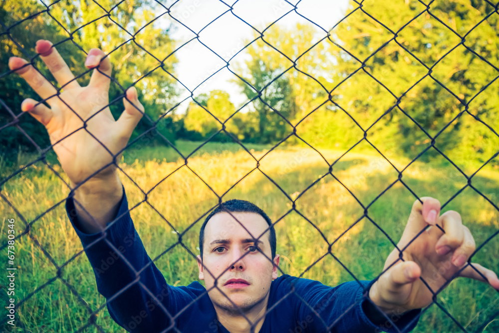 Hombre Joven Atrapado detrás de una malla metálica Stock Photo | Adobe ...