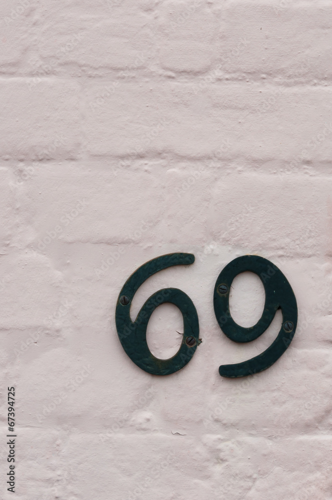 Number 69 on a white brick wall for use a background Stock Photo ...