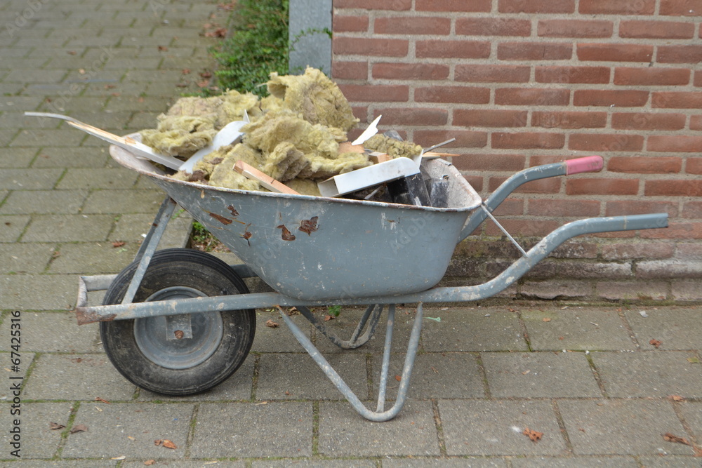 een kruiwagen met puin wordt afgevoerd Stock Photo | Adobe Stock