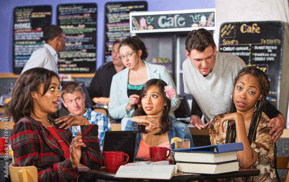 Man Annoying Students in Cafe Stock-Foto | Adobe Stock