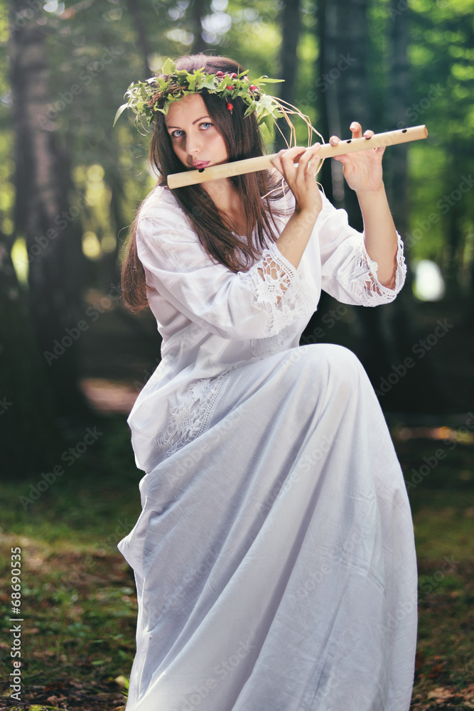 Beautiful woman playing a flute in the woods Stock Photo | Adobe Stock