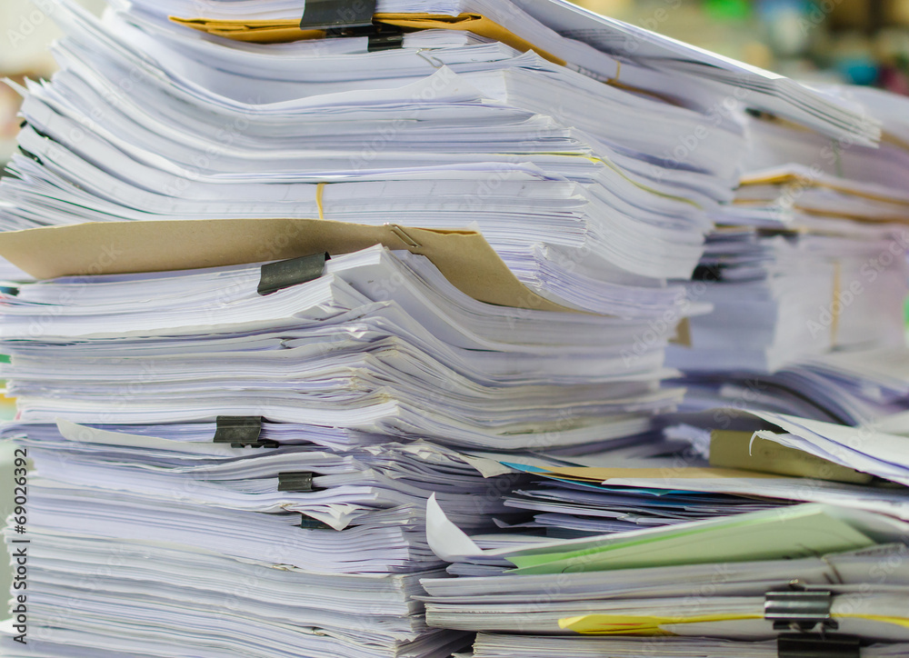 Pile of documents on desk stack up high waiting to be managed. Stock ...