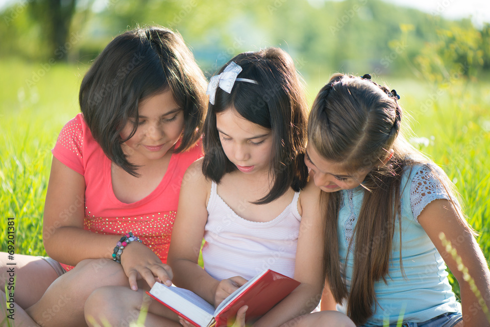 Three happy teen girls reading Stock Photo | Adobe Stock