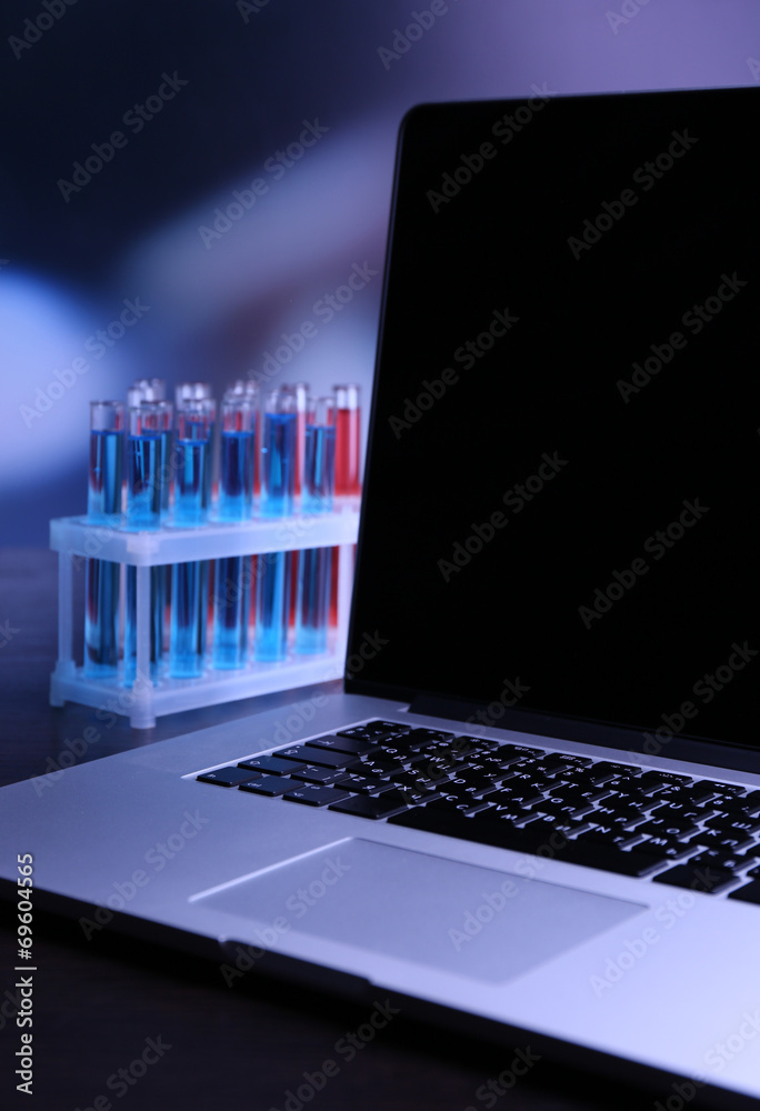 Laptop with test tubes in a laboratory on blue background Stock Photo ...