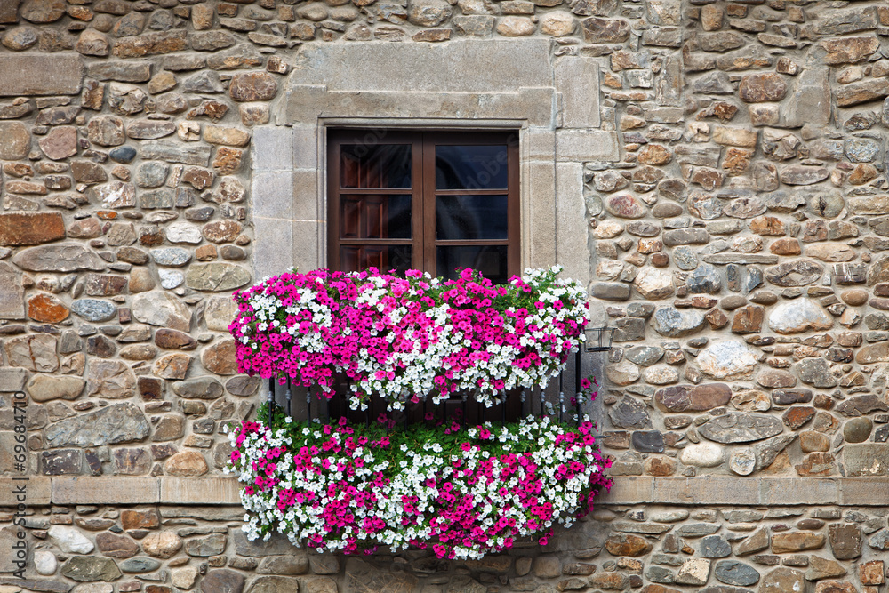 flowers in a window with stone facade Stock-Foto | Adobe Stock