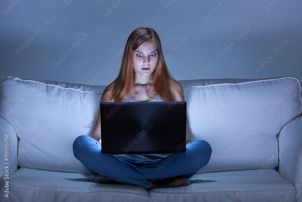 Shocked girl using facebook at night Stock Photo | Adobe Stock
