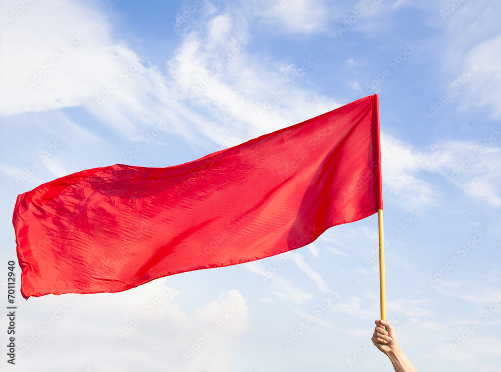 Hand waving a red flag with blue sky background Stock Photo | Adobe Stock