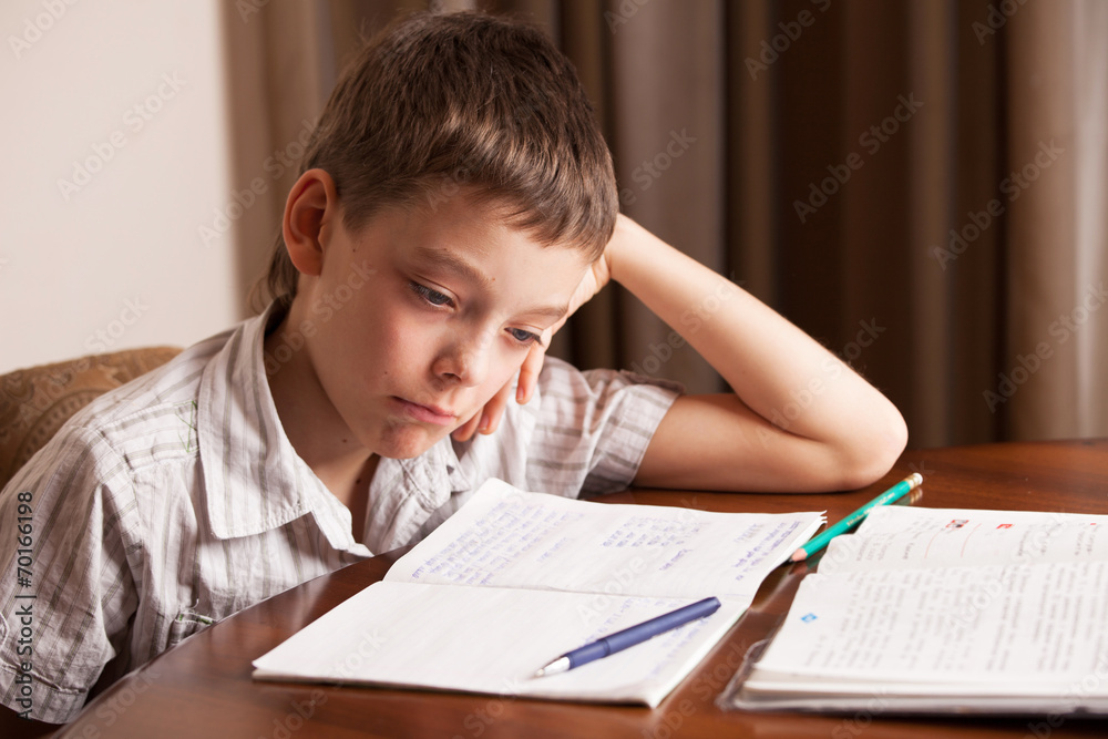 Sad boy doing homework Stock Photo | Adobe Stock