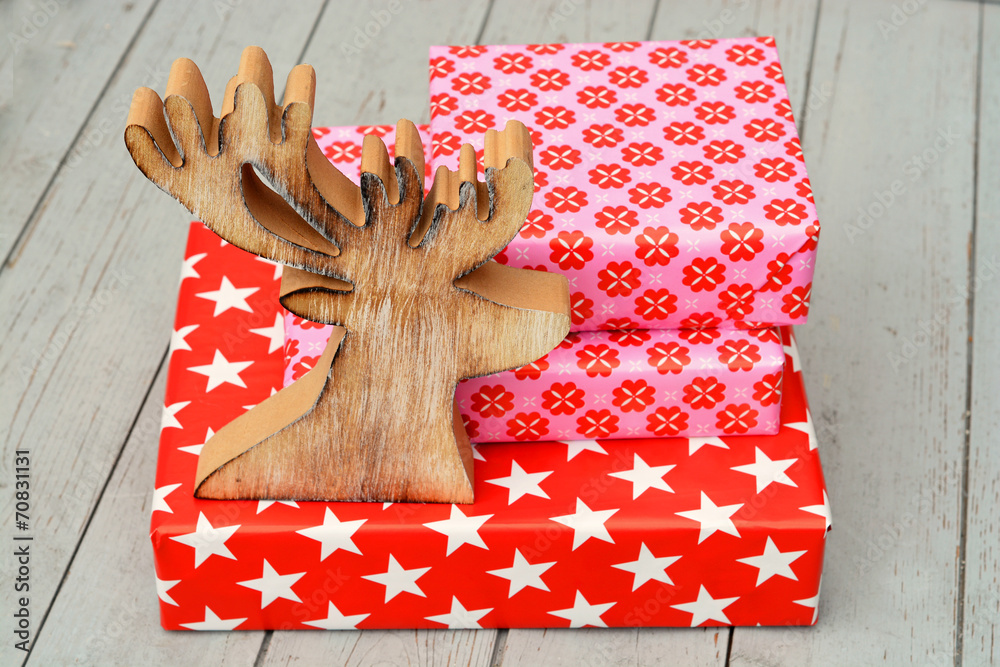 Gekleurde rode pakjes op oud hout met rendier Photos | Adobe Stock