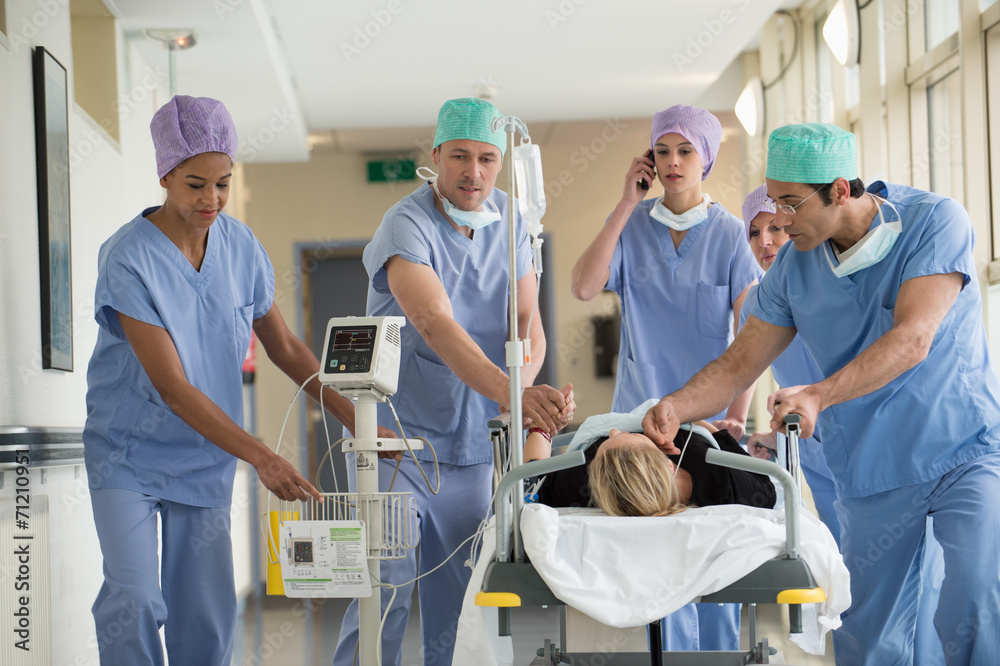 Medical Professionals Pushing Patient On Gurney In A Hospital Stock