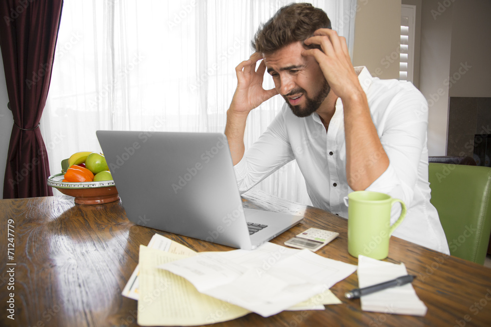 Angry man doing his taxes at home Stock-Foto | Adobe Stock