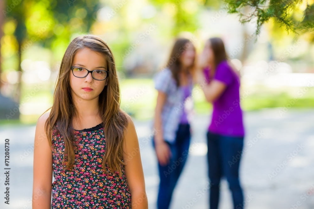 Sad girl in front of her evil girlfriends Stock Photo | Adobe Stock