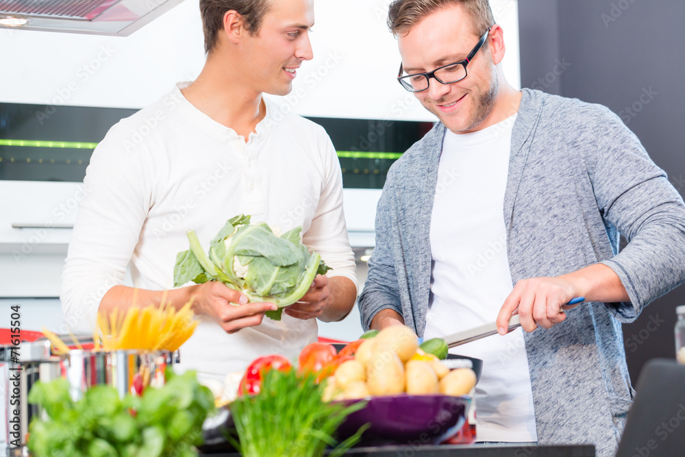Freunde kochen Gemüse und Fleisch zuhause in Küche Stock-Foto | Adobe Stock