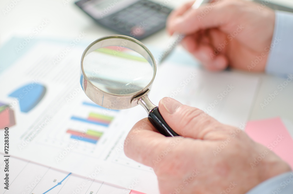 Businessman checking a graph with a magnifying glass Stock Photo ...
