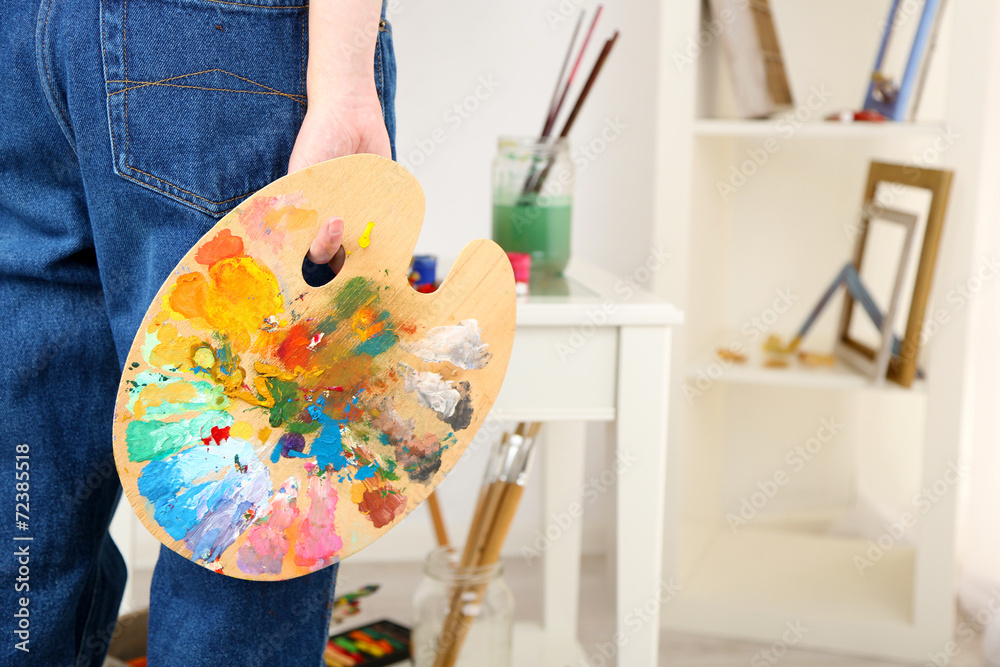 Artist holding palette with paints in art studio Stock Photo | Adobe Stock