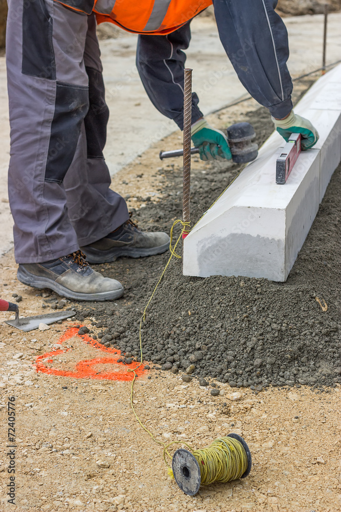 worker installing concrete curb stone and using string foto de Stock ...