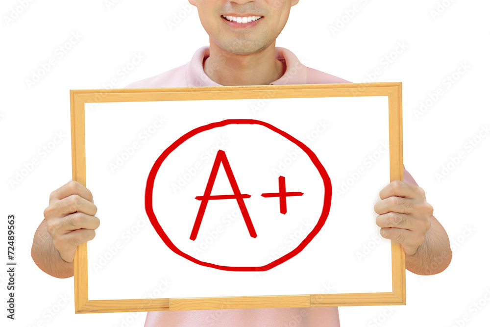 A+ sign on whiteboard held by smiling man Stock Photo | Adobe Stock