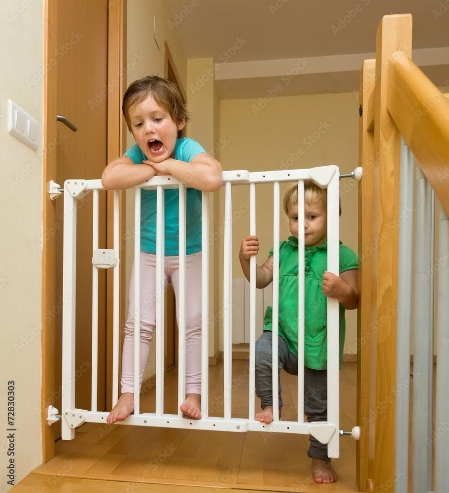 Two girls approaching safety gate of stairs Stock Photo | Adobe Stock