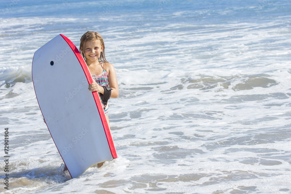 Cute little girl boogie boarding in the ocean Stock Photo | Adobe Stock