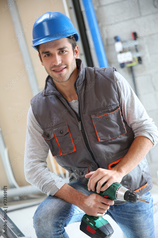Construction worker holding electric drill Stock Photo | Adobe Stock