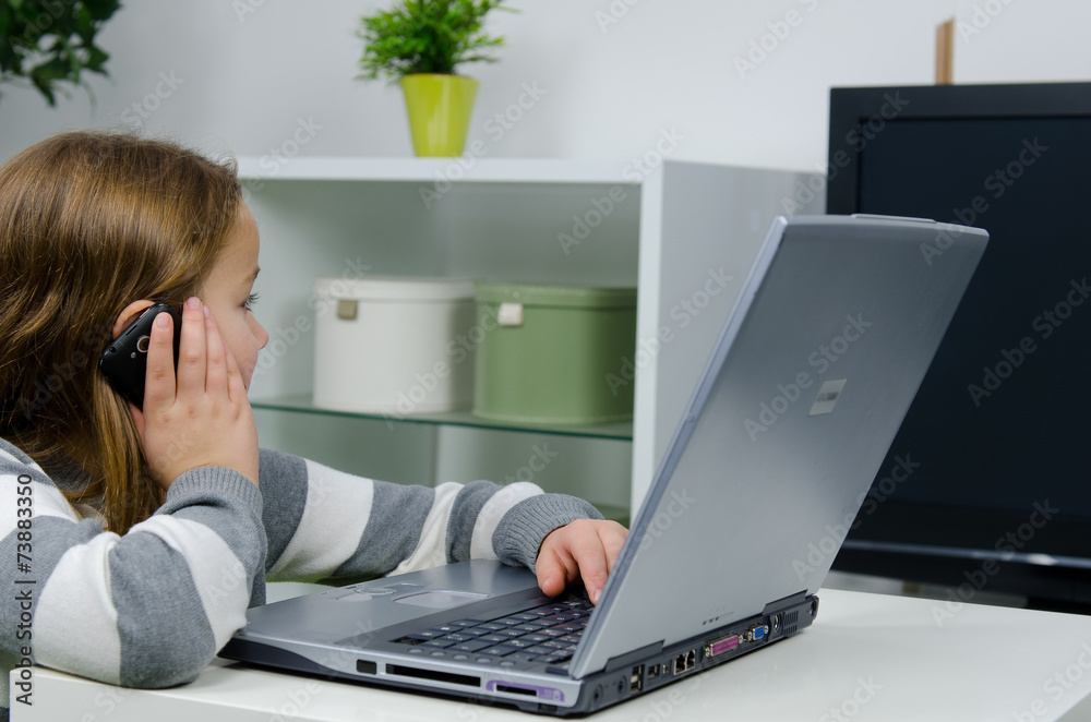 kind sitzt am computer, fernsehen und handy Stock-Foto | Adobe Stock