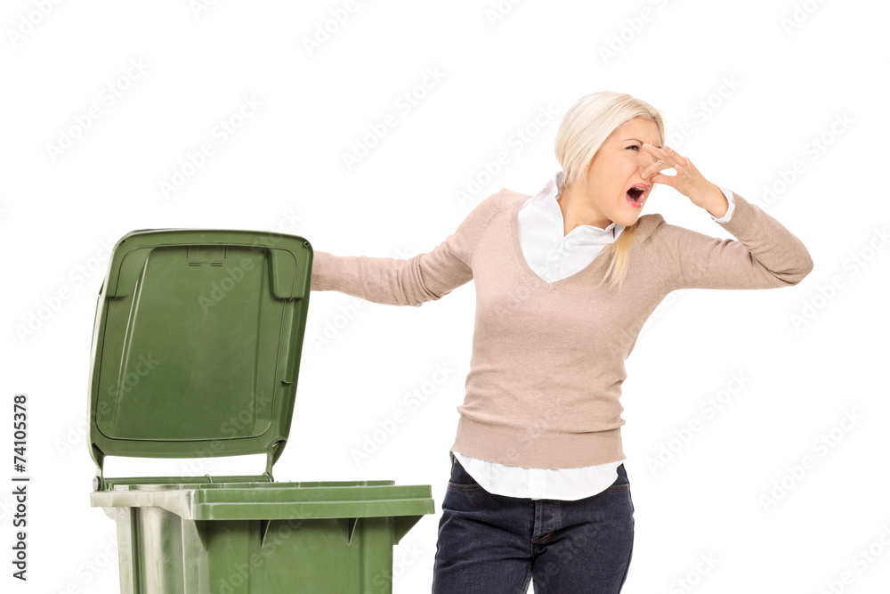 Foto de Woman opening a stinky trash can do Stock | Adobe Stock