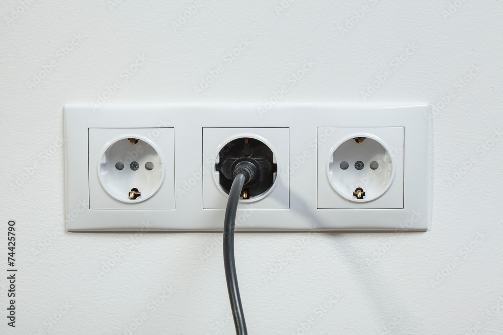 Black power plug plugged in a electric socket Stock Photo | Adobe Stock