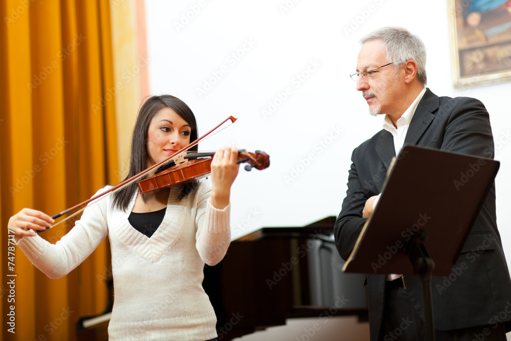 Violin teacher helping a student Stock Photo | Adobe Stock