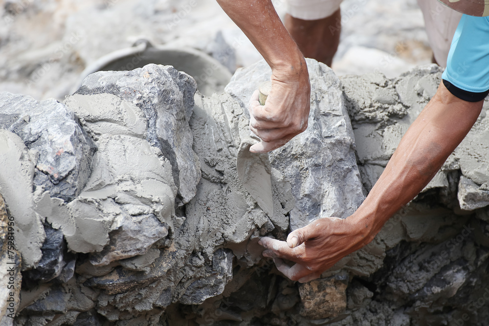 Construction workers build a stone wall Stock Photo | Adobe Stock
