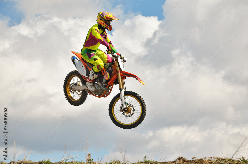 Motocross rider on a motorcycle spectacularly lands on a edge of Stock ...