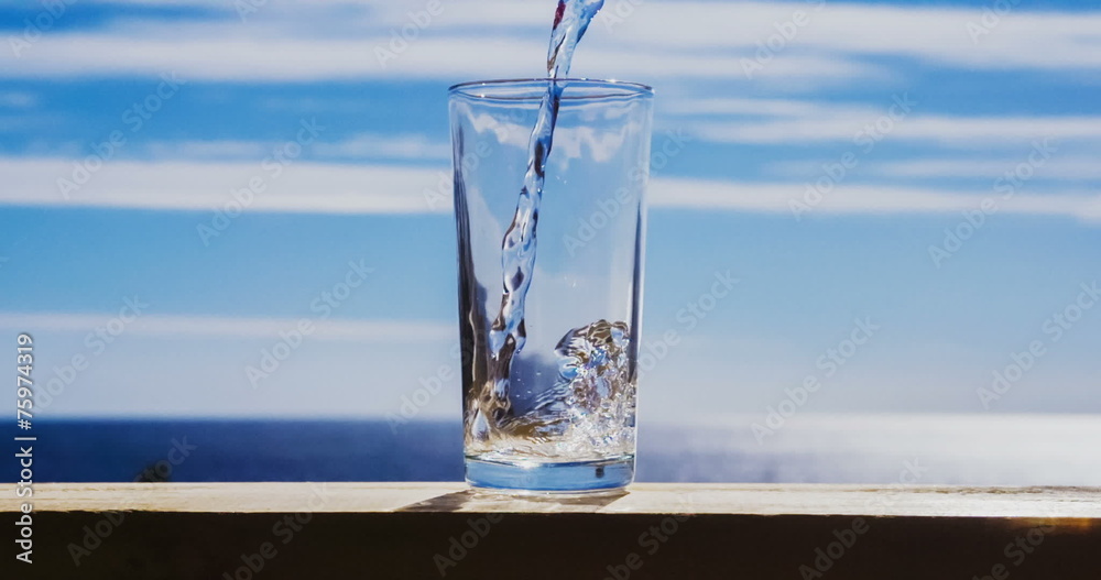 Blue water is flowing into the glass forming bubbles Stock Video ...