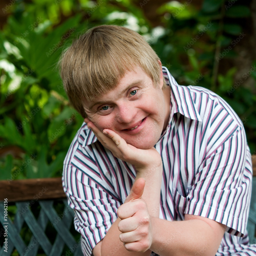 Cute boy with down syndrome doing thumbs up in garden. Stock Photo ...