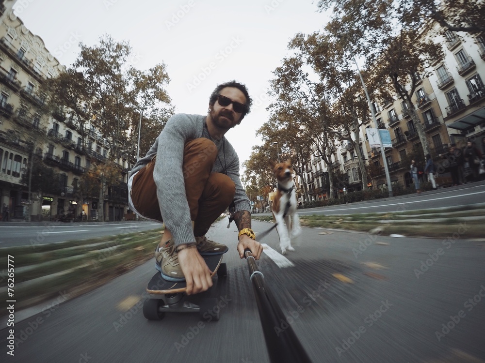 Man rides his skateboard followed by his dog Stock Photo | Adobe Stock