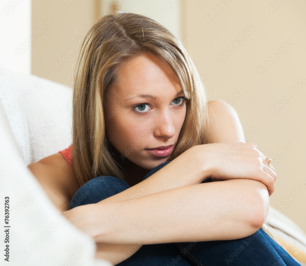 Sad girl sitting on couch Stock Photo | Adobe Stock