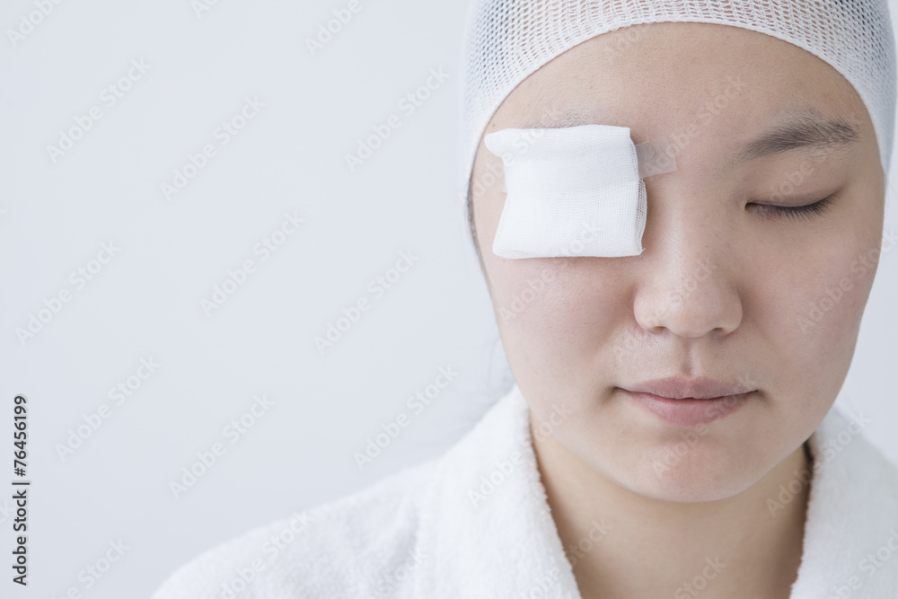 Woman wearing a gauze in one eye Stock Photo | Adobe Stock