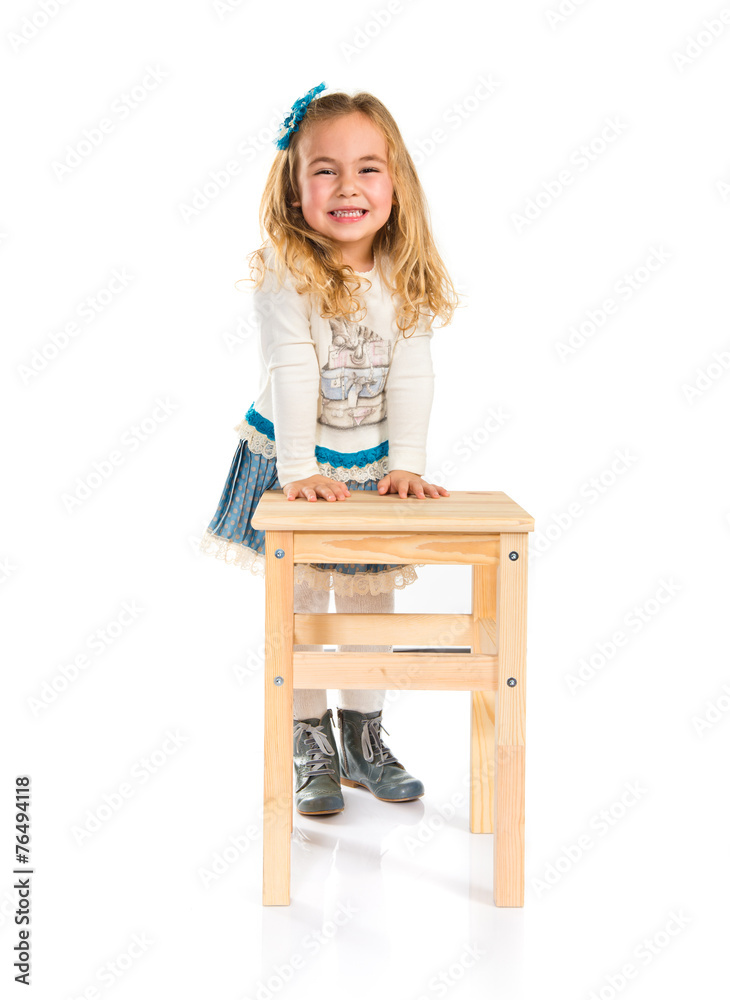 Little blonde girl leaning on chair Stock Photo | Adobe Stock